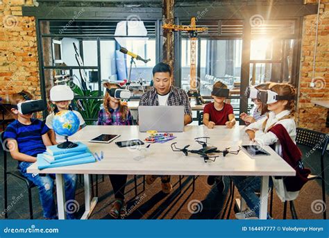 Korean Teacher With Six Caucasian Pupils Using Augmented Reality Vr