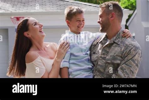 Happy Caucasian Male Soldier Embracing His Smiling Son With Wife In