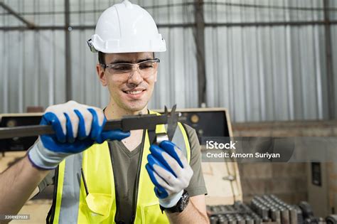 산업 공장에서 Cnc 기계의 부품을 검사하는 전문 남성 엔지니어 안전 유니폼 고글 및 헬멧이 있는 선반 기계에서 품질 생산을 확인하는 남성 작업자 25 29세에 대한 스톡