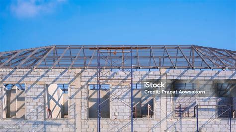 푸른 하늘 배경에 대한 건설 현장의 불완전한 현대 사무실 건물의 금속 엉덩이 지붕 빔 구조와 콘크리트 블록 벽 0명에 대한 스톡 사진 및 기타 이미지 Istock