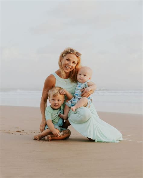 Young Caucasian Mother Spending Time On The Beach With Sons Mom
