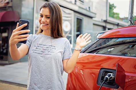 젊은 여자는 셀카를 복용 그녀의 전기 자동차를 충전 할 때까지 화상 통화를 만들기 셀카에 대한 스톡 사진 및 기타 이미지 셀카 전기 자동차 대체 연료 자동차 전기