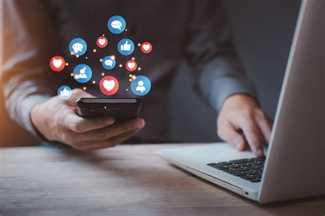 가상 빨간색 하트와 파란색 이모티콘 소셜 미디어 아이콘으로 스마트 폰에서 채팅 및 알림 홀로그램으로 휴가 중에 스마트폰을 사용하는 남자 소셜 미디어 및 디지털 온라인 개념