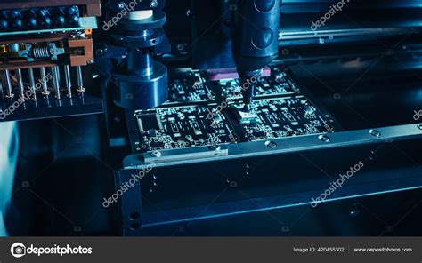 Factory Machinery At Work Printed Circuit Board Being Assembled With Automated Robotic Arm