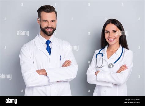 Portrait Of Two Cheerful Intelligent Surgeon Doctors Crossed Hands