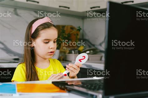 학교로 돌아갑니다 집에서 디지털 태블릿 노트북 노트북을 가지고 공부하고 학교 숙제를하는 여학생 소녀 교과서가 있는 테이블에 앉아 있습니다 6 7 살에 대한 스톡 사진 및