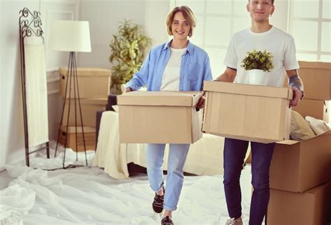 Premium Photo Couple Holding Boxes For Moving The Hands And Looking Inside Box