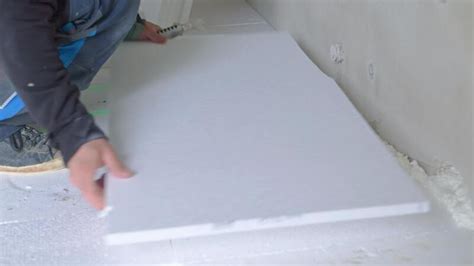 Construction Worker Installing Styrofoam Insulation Panels On Floor