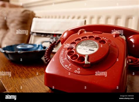 A British Telecom Or Bt Red Telephone With Old Fashioned Dial Stock