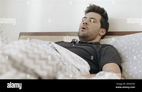 Sleepy Man Yawning On Bed In Morning Handsome Guy Stretching In