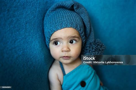 파란색 모자에 귀여운 신생아 푸른 배경에 행복한 아기 신생아의 클로즈업 초상화 아기 상품 포장 템플릿 보육 의료 및 건강 한 개념 크리스마스 새해 건강관리와 의술에 대한