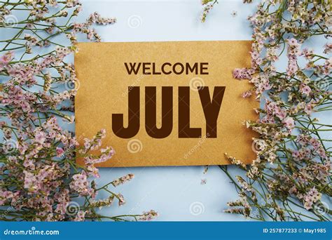 Welcome July Written On Paper Card With Flower Frame Decoraton On Pink