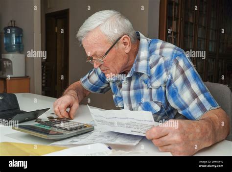 Senior Man Sitting At The Table And Calculating Finances Old Man