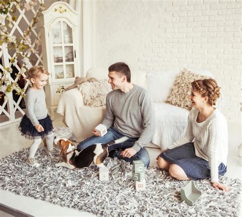 Familia Feliz Jugando Con Un Perro Mascota En La Espaciosa Sala De Estar Foto Premium