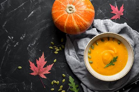 검은 돌 배경에 씨앗을 곁들인 호박 크림 수프 겨울과 가을 다이어트 수프 상단 보기 플랫 레이 복사 공간 0명에 대한 스톡 사진