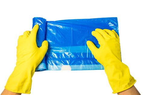 노란 고무 장갑을 낀 사람의 손이 쓰레기 봉투의 파란색 롤을 펼칩니다 노랑에 대한 스톡 사진 및 기타 이미지 노랑 비닐 봉지 장갑 Istock