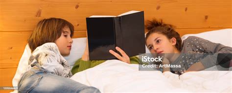 엄마와 아이들은 잠자리에 들기 전에 함께 책을 읽습니다 3 명에 대한 스톡 사진 및 기타 이미지 3 명 가정 생활 가정의