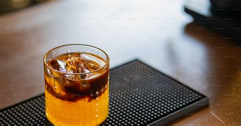 아시아 여성 바리스타가 잔에 신선한 오렌지 주스에 에스프레소를 붓고 있다 여성 커피숍 웨이트리스는 카페 카운터에서 고객에게