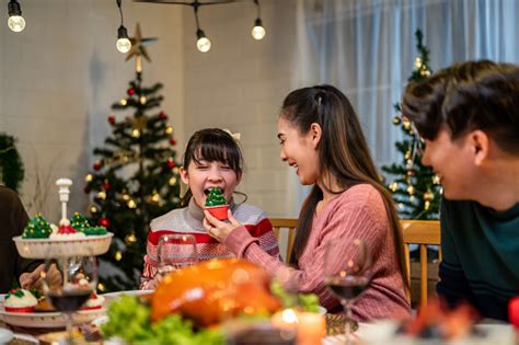 집에서 함께 크리스마스 파티를 축하하는 아시아 사랑스러운 가족 휴일 추수 감사절을 축하하기 위해 음식을 먹고 집에서 식탁에 크리스마스 이브를 먹는 매력적인 부모와 친척 12