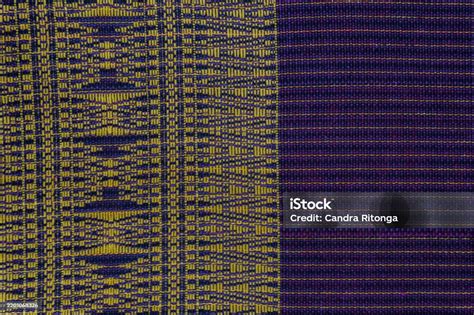 금색과 보라색의 대조적인 기하학적 패턴이 특징인 생동감 넘치는 직물입니다 이 디자인은 전통적인 직조 기술과 풍부한 색상 팔레트를