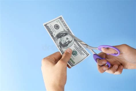 Budgeting Man Cutting Dollar Banknote With Scissors On Light Blue