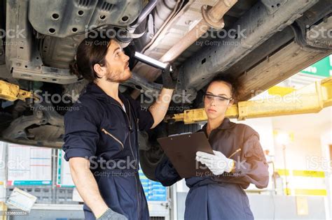 기술자 작업자는 렌치 도구를 사용하여 차 아래 유지 보수 자동차 엔진을 사용합니다 차고에서 자동차 상태 하에서 정비사 차량 서비스 유지 보수 점검 그룹 기계공에 대한 스톡