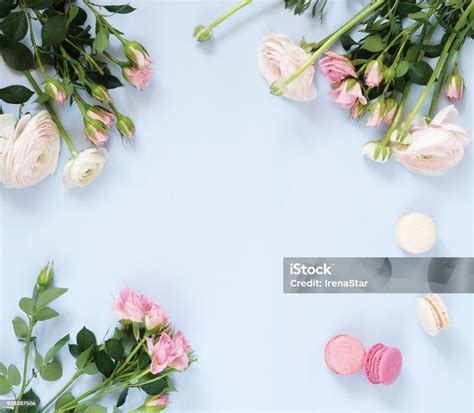 휴일 꽃 배경입니다 창백한 핑크 장미와 옅은 파란색 배경에 미나리 아재 비 꽃과 마카롱 케이크의 아름 다운 꽃다발 최고의 볼 수 있습니다 공간에 복사 합니다 평면 배치 0