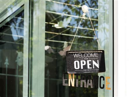 Hanging Sign With Message WELCOME OPEN On Glass Door At Coffee Shop