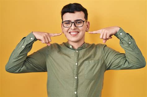 Non Binary Person Standing Over Yellow Background Smiling Cheerful Showing And Pointing With