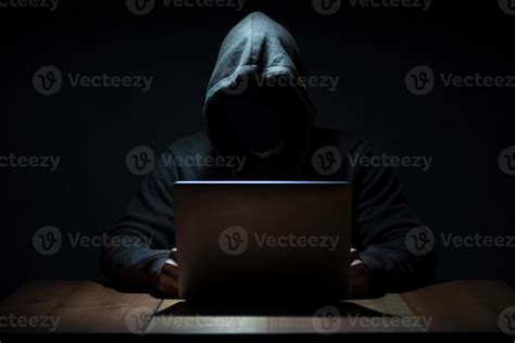 Hacker Wearing Black Hoodie Using Laptop Computer While Working On Dark