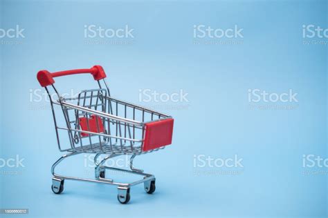 파란색 배경에 슈퍼마켓 쇼핑 카트입니다 전자 상거래 웹 사이트 마케팅 자료 또는 소매 소비주의 및 쇼핑 트렌드를 중심으로 하는