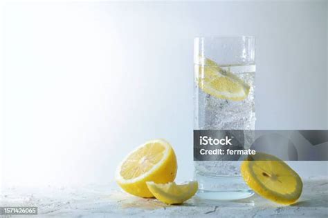 음료수 잔에 얼음 조각과 레몬이 있는 탄산 소다수 밝은 회색 배경에 대한 상쾌한 음료 복사 공간 선택한 초점 물에 대한 스톡