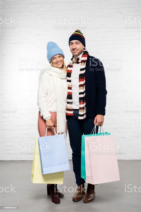 남편과 겨울 옷을 입고 카메라를 바라보 고 쇼핑백을 들고 아내 겨울에 대한 스톡 사진 및 기타 이미지 겨울 미소 사람들 Istock