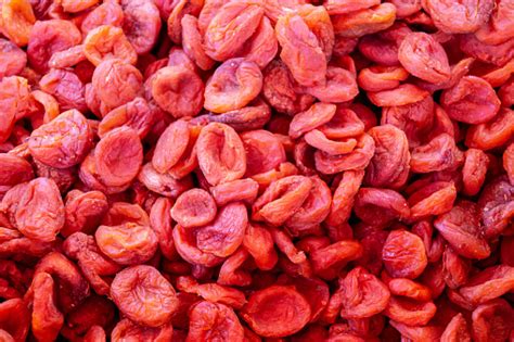 태양 패턴 배경에 말린 살구 열매 농장에서 유기농 천연 말린 살구 짙은 오렌지 말린 살구 과일 근접 촬영 매크로입니다 건조 한 과일 배경 건강 한 달콤한 채식 음식 탈수 된