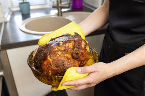 Manos De Mujer Sacando Del Horno El Pollo Asado Imagen De Archivo