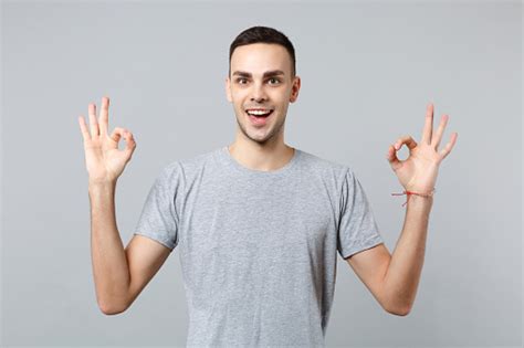 요가 제스처에 손을 잡고 캐주얼에 흥분 젊은 남자의 초상화 스튜디오에서 회색 배경에 고립 명상 휴식 사람들은 진심으로 감정 라이프 스타일 개념입니다 복사 공간을 모의 합니다