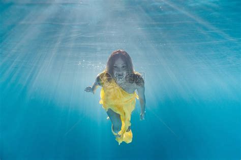 在游泳池游泳时身着洋装的年轻美女高清图片下载 正版图片503525879 摄图网
