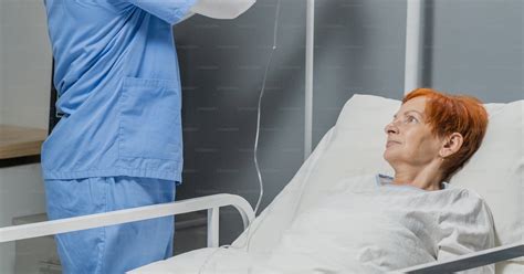 아프리카 마취과 의사는 병원에서 침대에 누워 있는 동안 아픈 노인 여성을 위해 스포이드를 만드는 제복을 입고 있다 사진 Unsplash의 의사 이미지