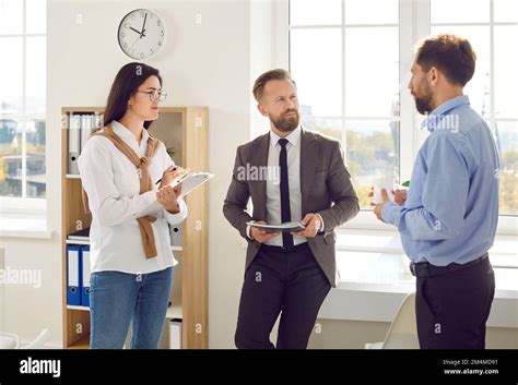 Two Businessmen And Female Trainee Or Secretary Are Discussing Work