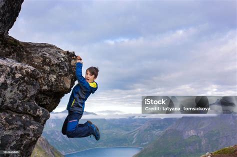 노르웨이 북부 센자 섬의 세글라 산 너머의 바위에 매달려 있는 행복한 아이 스칸디나비아 국가에서 놀라운 아름다운 풍경과 화려한 자연 걷기에 대한 스톡 사진 및 기타 이미지