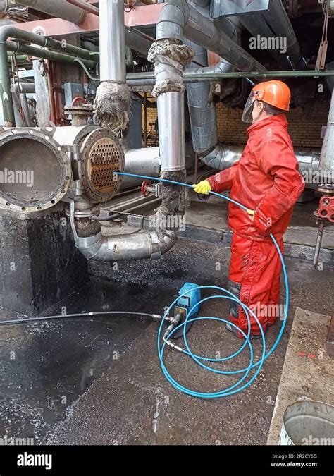 Man Cleaning Condenser Tubes Removing Scales Of Petrochemical Industrial Heat Exchanger With
