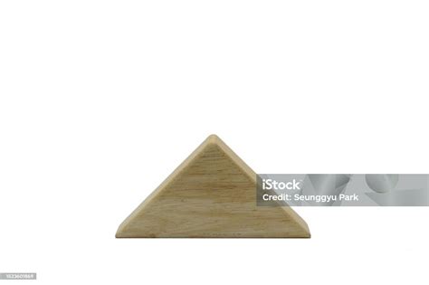 A Triangular Wooden Block Placed In Front Of A White Background Stock