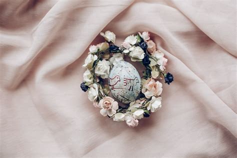 소박한 흰색 나무 배경 플랫 레이에 베이지색 패브릭에 꽃이 있는 꽃 둥지에 병아리 장식이 있는 부활절 달걀 행복한 부활절 인사말 카드 텍스트를 위한 공간 평면도 사진