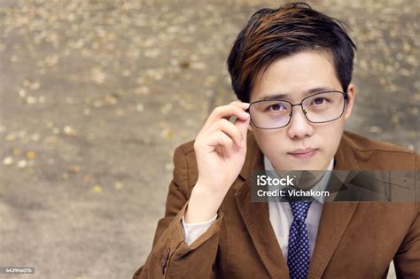 아시아 비즈니스 남자 갈색 슈트와 그의 유리를 잡고 이며 올려 텍스트에 대 한 공간을 복사 합니다 갈색에 대한 스톡 사진 및