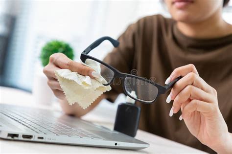 Women Hand Cleaning Trendy Black Glasses Lens With White Cream