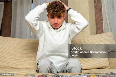 곱슬 머리를 가진 백인 청년이 퍼즐을 조립하는 데 집중합니다 20 24세에 대한 스톡 사진 및 기타 이미지 20 24세 거실 남성 Istock