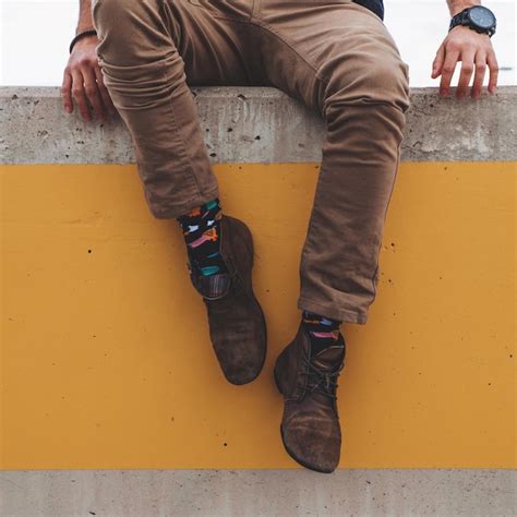 Premium Photo Low Section Of Man Sitting On Orange Retaining Wall