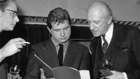 Ирландският художник Франсис Бейкън в центъра чете каталога на изложбата си в галерия