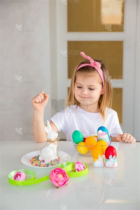小女孩坐在桌子旁装饰复活节彩蛋素材 花瓣网