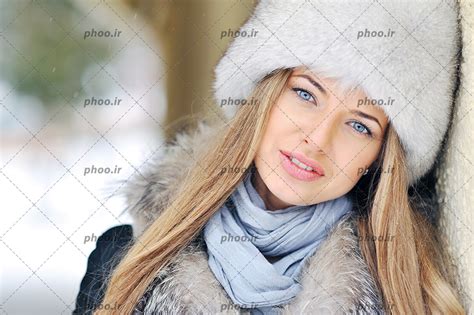 عکس دختر زیبا با چشم های آبی و مو های بلوند و لباس گرم در فضای باز و